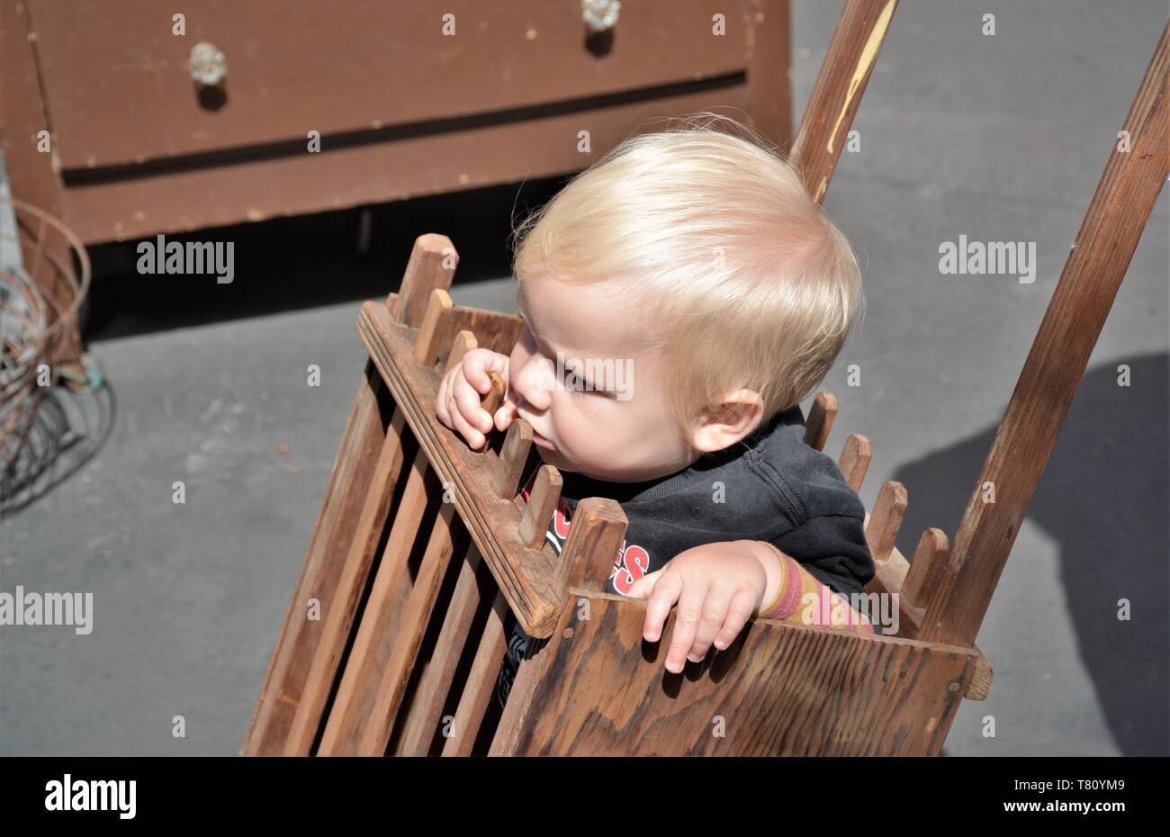 Real toddler boy riding in mom's shopping cart at a street fair in ...