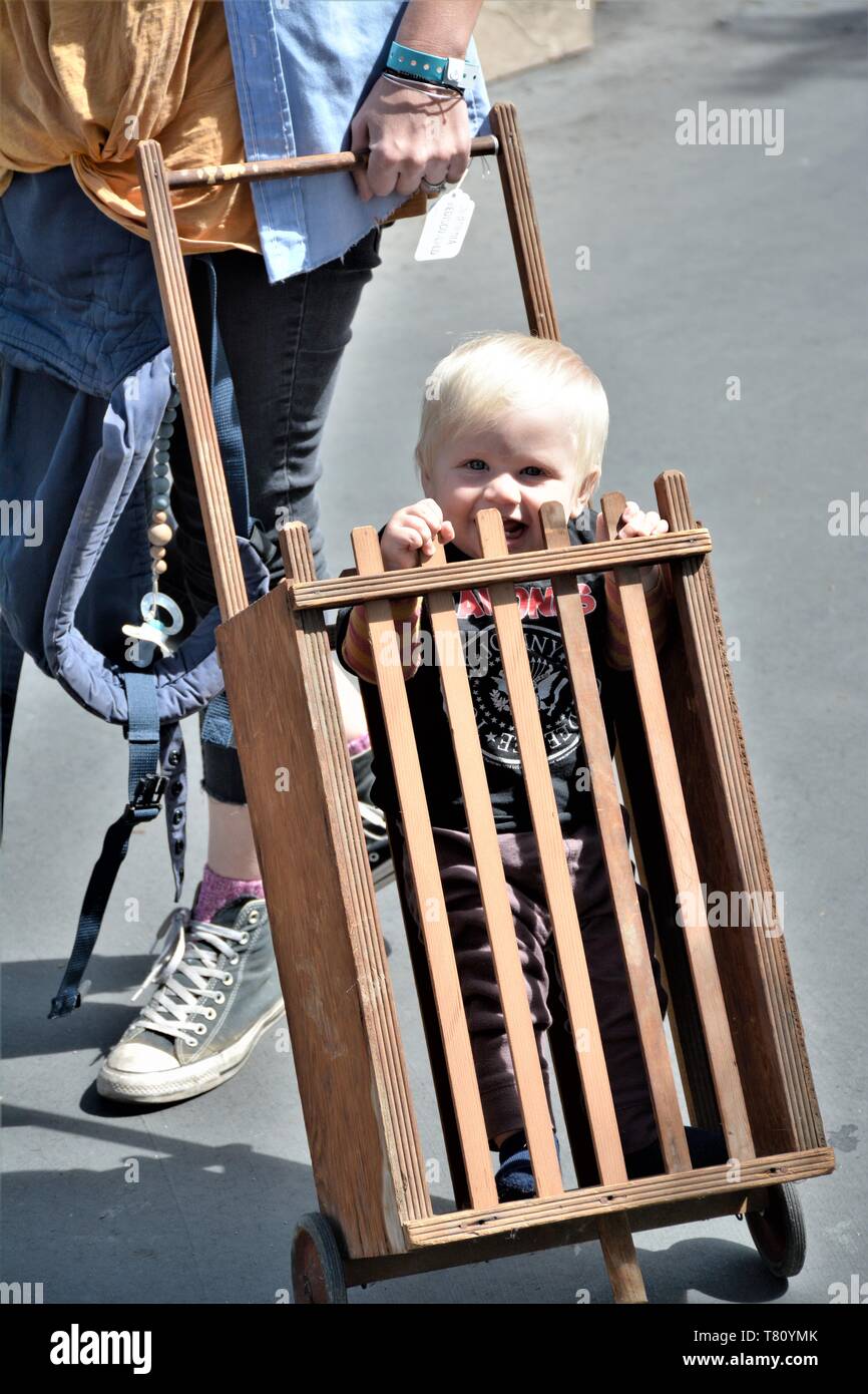 Real toddler boy riding in mom's shopping cart at a street fair in ...