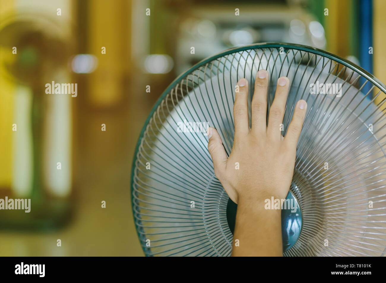 Hand of Young man touch and adjust on front grills of electric fan for ...