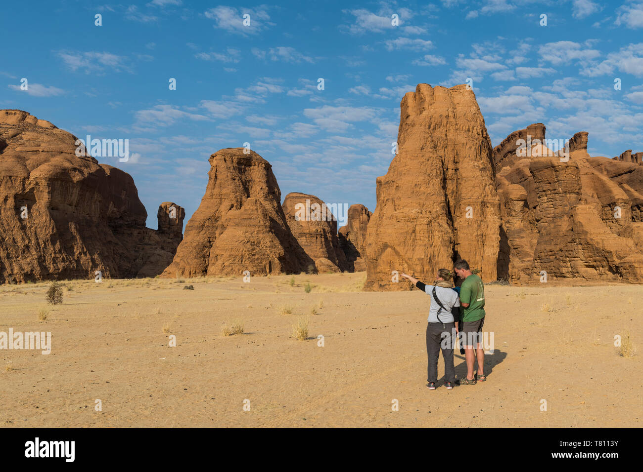 Couple looking at beautiful rock formations, Ennedi Plateau, UNESCO ...