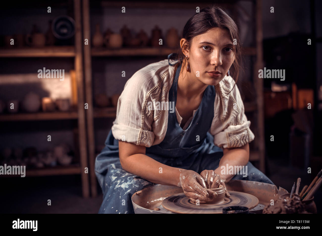 Charming pottery master shows how to work with clay and pottery wheel ...