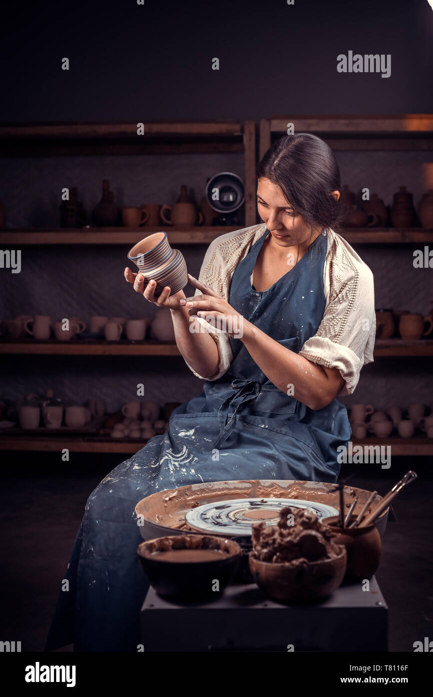 Beautiful artisan demonstrates the process of making ceramic dishes ...