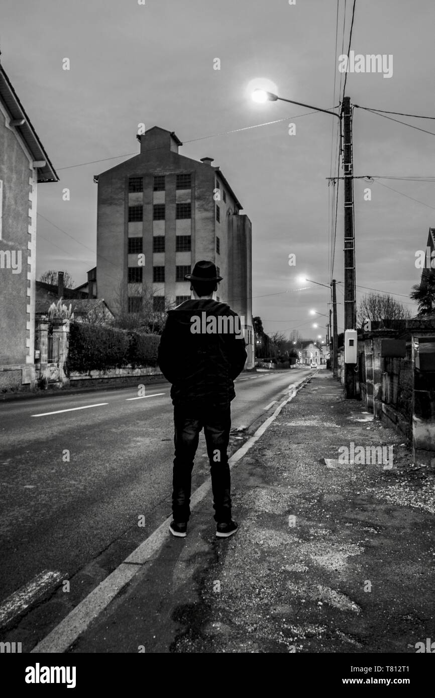 Man in the street facing a road at night time hi-res stock photography ...
