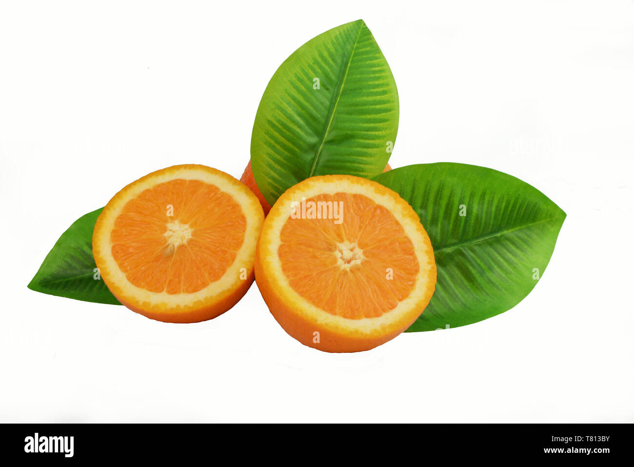 two half ripe orange fruit useful with leaf on an isolated white ...