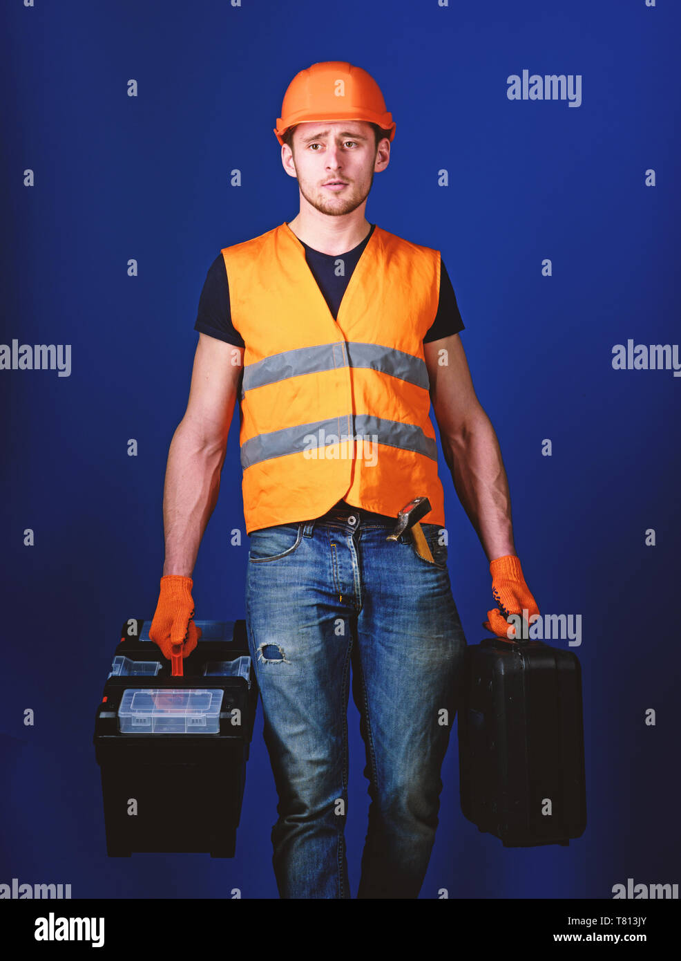 Professional repairman concept. Man in helmet, hard hat holds toolbox ...