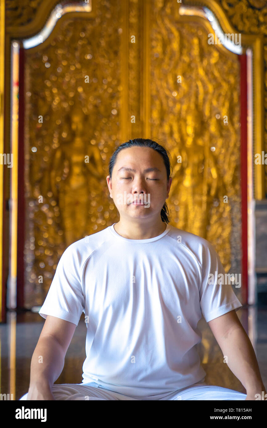 Asian long hair man relaxes meditation with all white costume sit in ...
