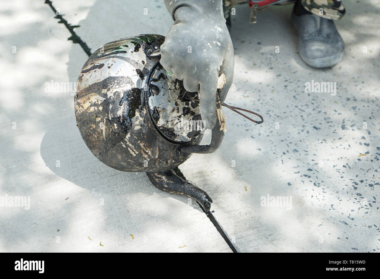 close up kettle asphalt in the worker rubber hand Stock Photo - Alamy