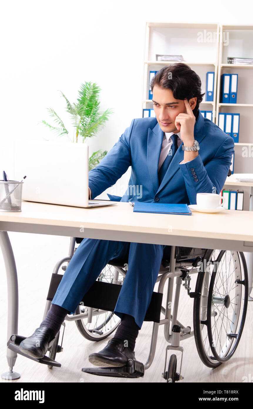 Male employee in wheelchair working at the office Stock Photo - Alamy
