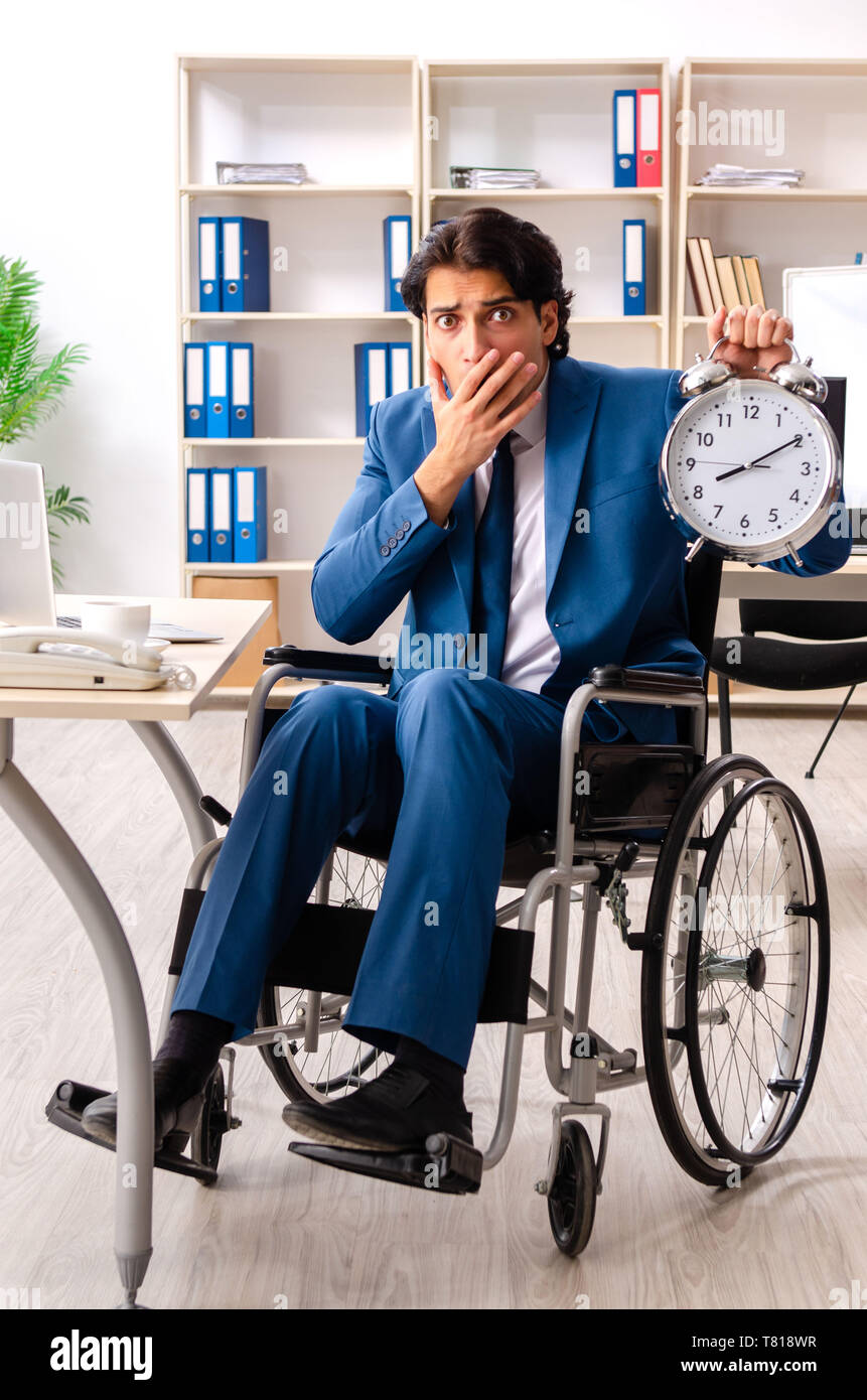 Male employee in wheelchair working at the office Stock Photo - Alamy