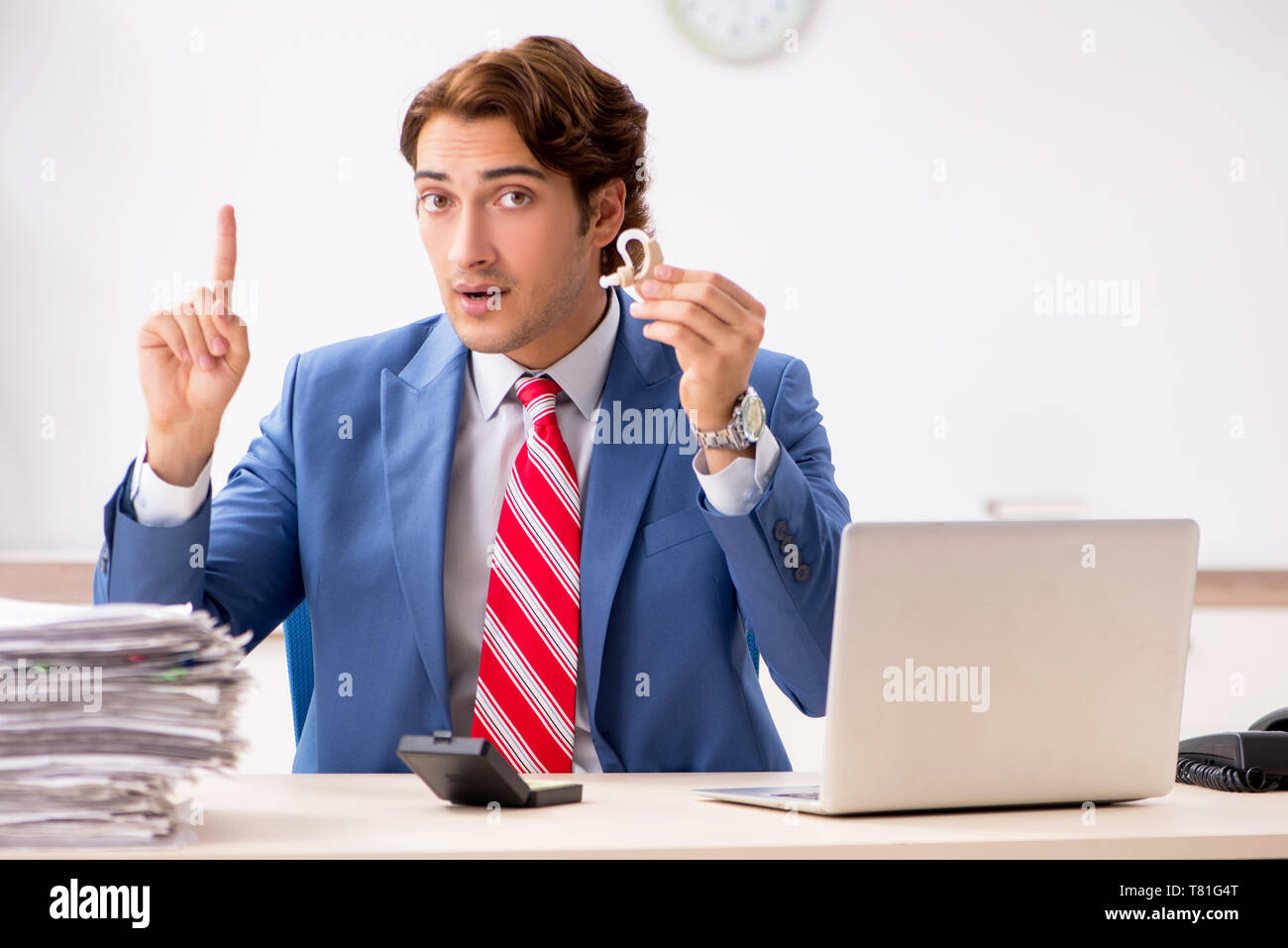 Deaf employee using hearing aid in office Stock Photo - Alamy