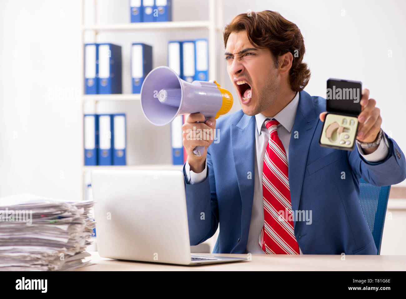 Deaf employee using hearing aid in office Stock Photo - Alamy