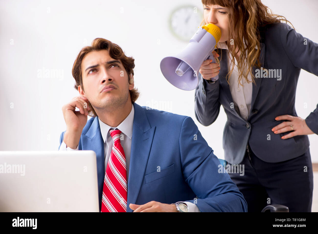 Deaf employee using hearing aid talking to boss Stock Photo - Alamy