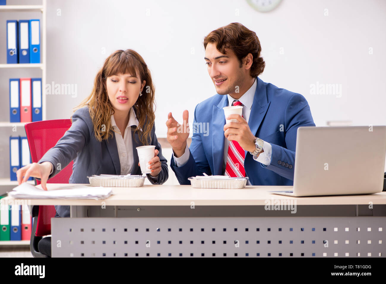 Two colleagues having lunch break at workplace Stock Photo - Alamy