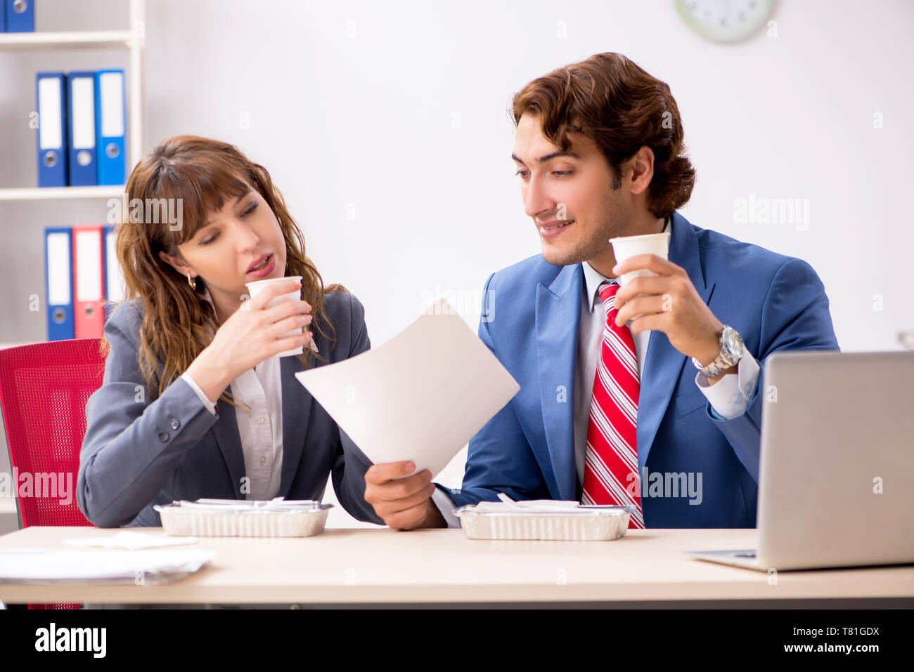 Two colleagues having lunch break at workplace Stock Photo - Alamy
