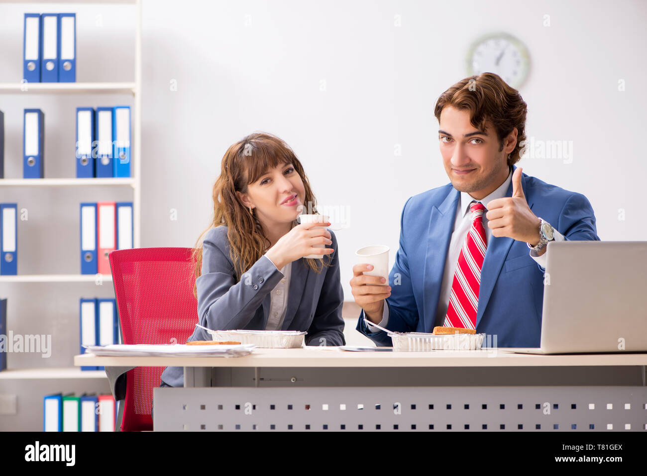 Two colleagues having lunch break at workplace Stock Photo - Alamy