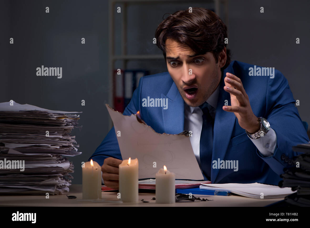 Businessman burning the evidence late in office Stock Photo - Alamy