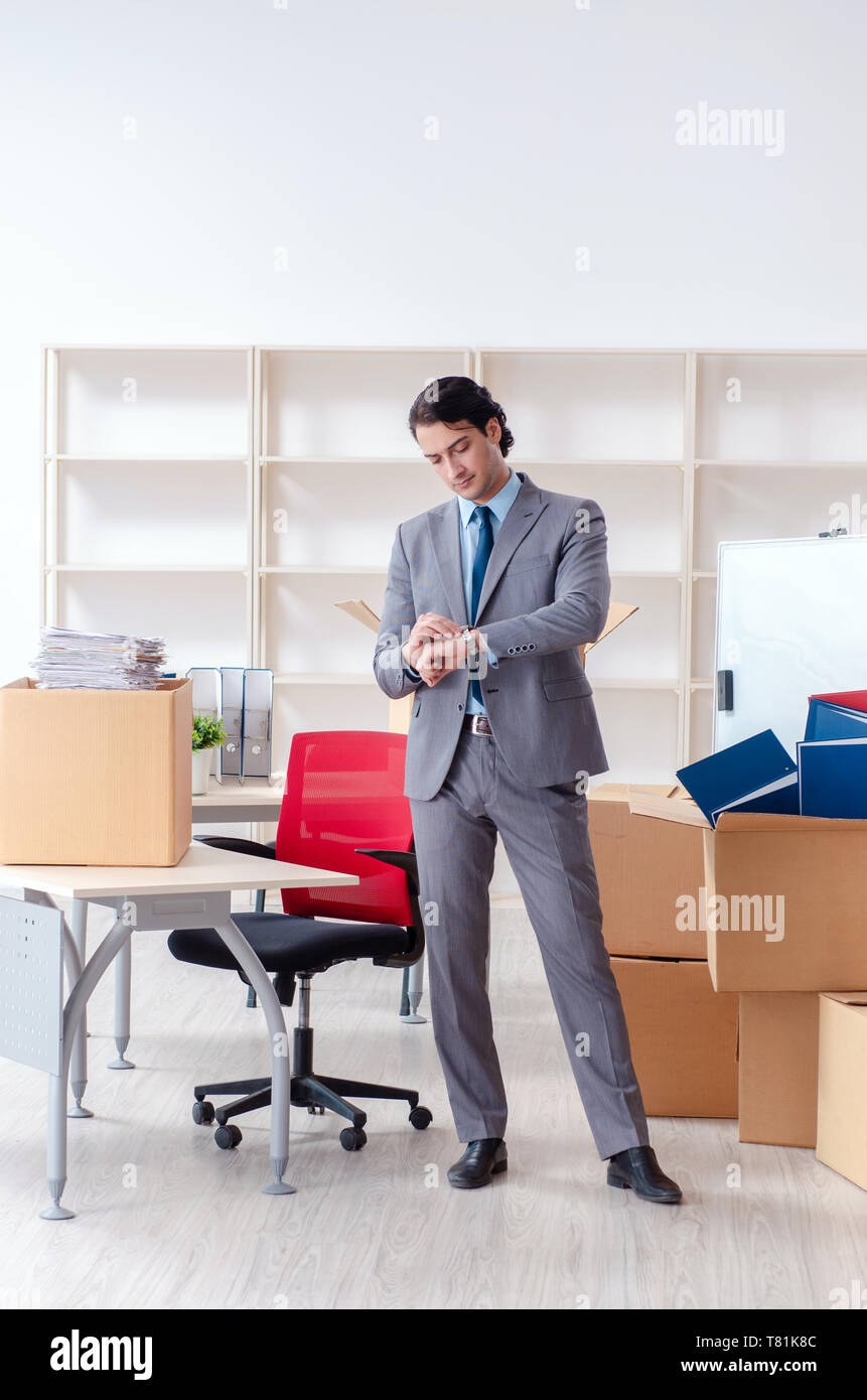 Young man employee with boxes in the office Stock Photo - Alamy