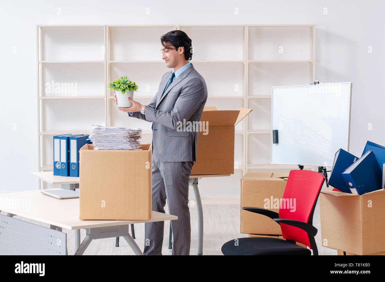 Young man employee with boxes in the office Stock Photo - Alamy