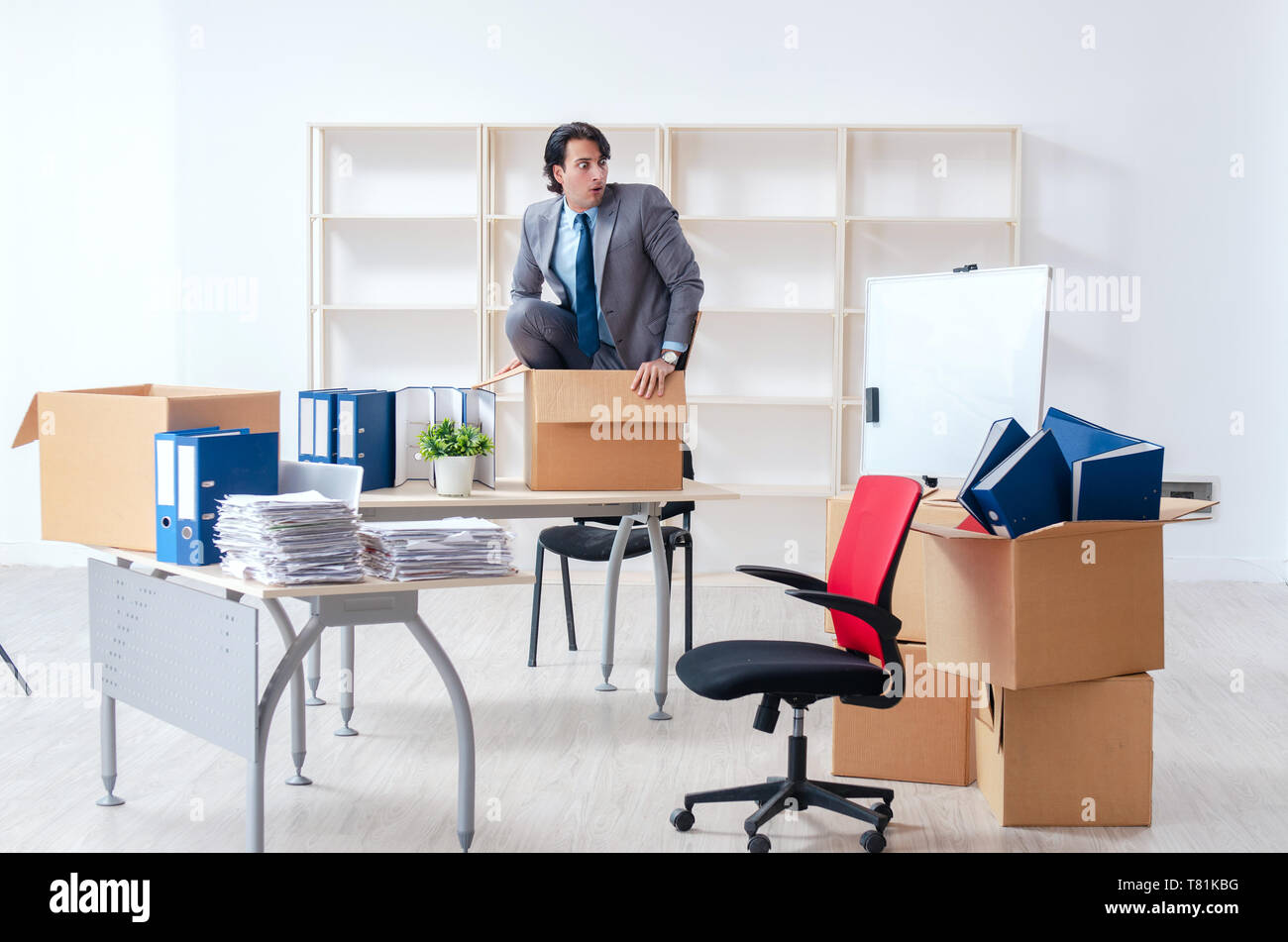 Young man employee with boxes in the office Stock Photo - Alamy