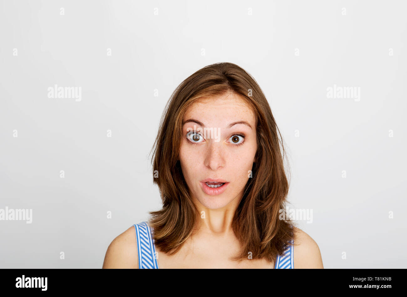 Amazed young woman looking at camera on white background Stock Photo ...