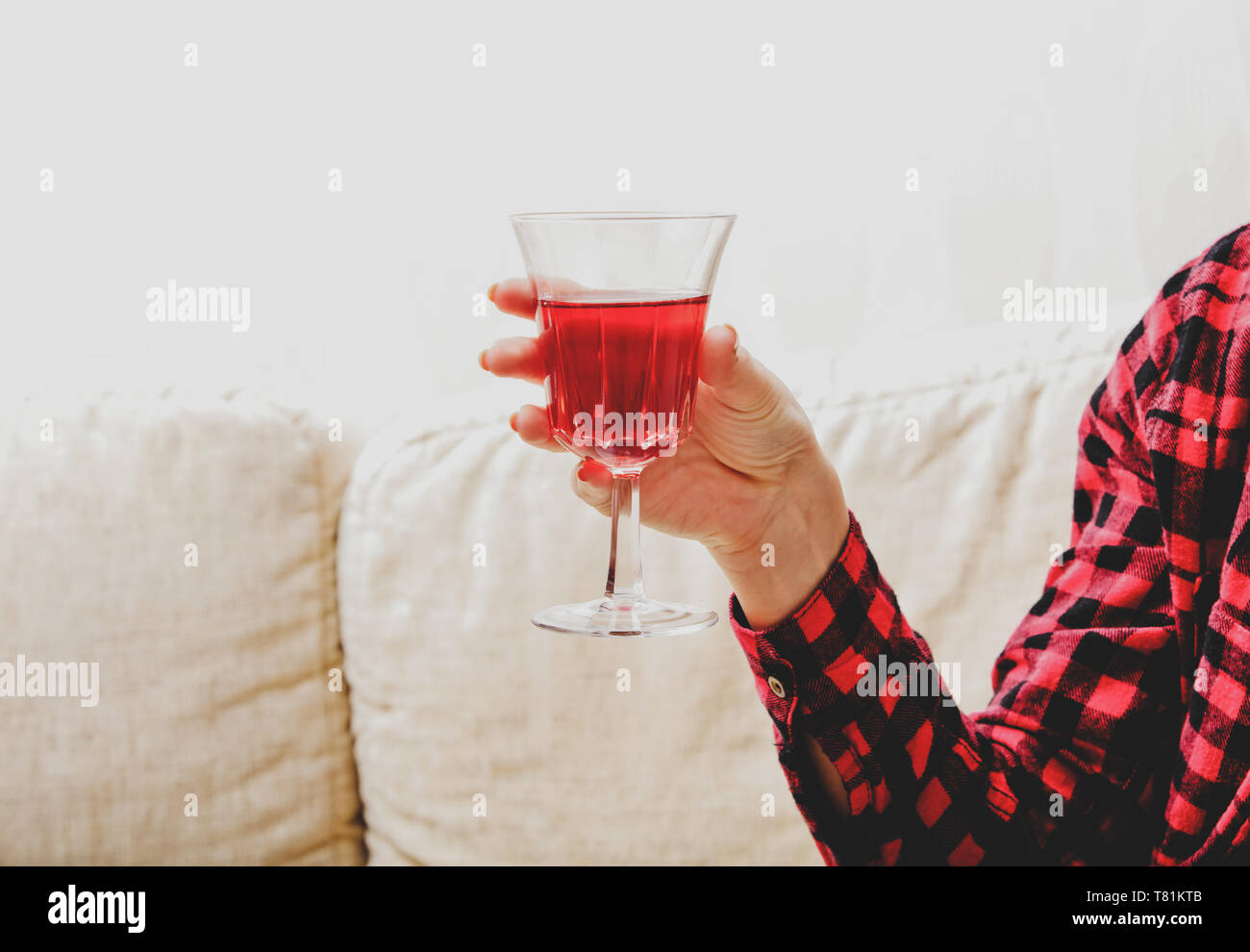 Woman's hand holding glass with red wine in home interior Stock Photo ...