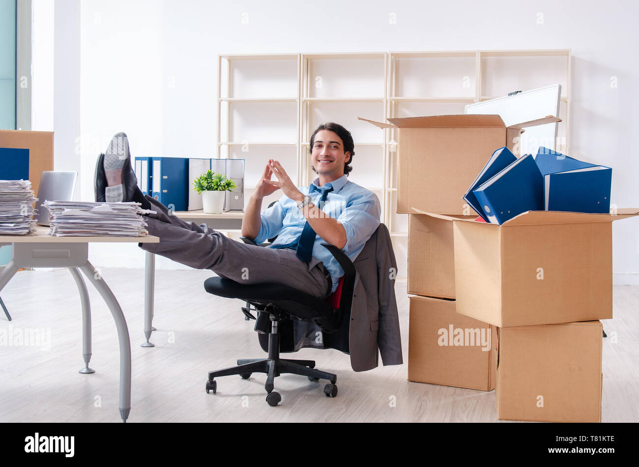 Young man employee with boxes in the office Stock Photo - Alamy