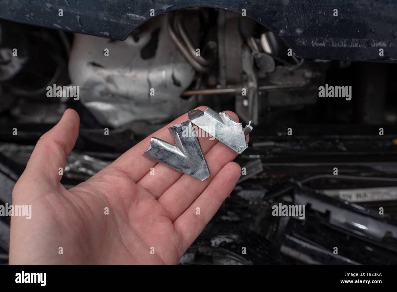 Volkswagen Badge, smashed badge and engine components. Car crash ...