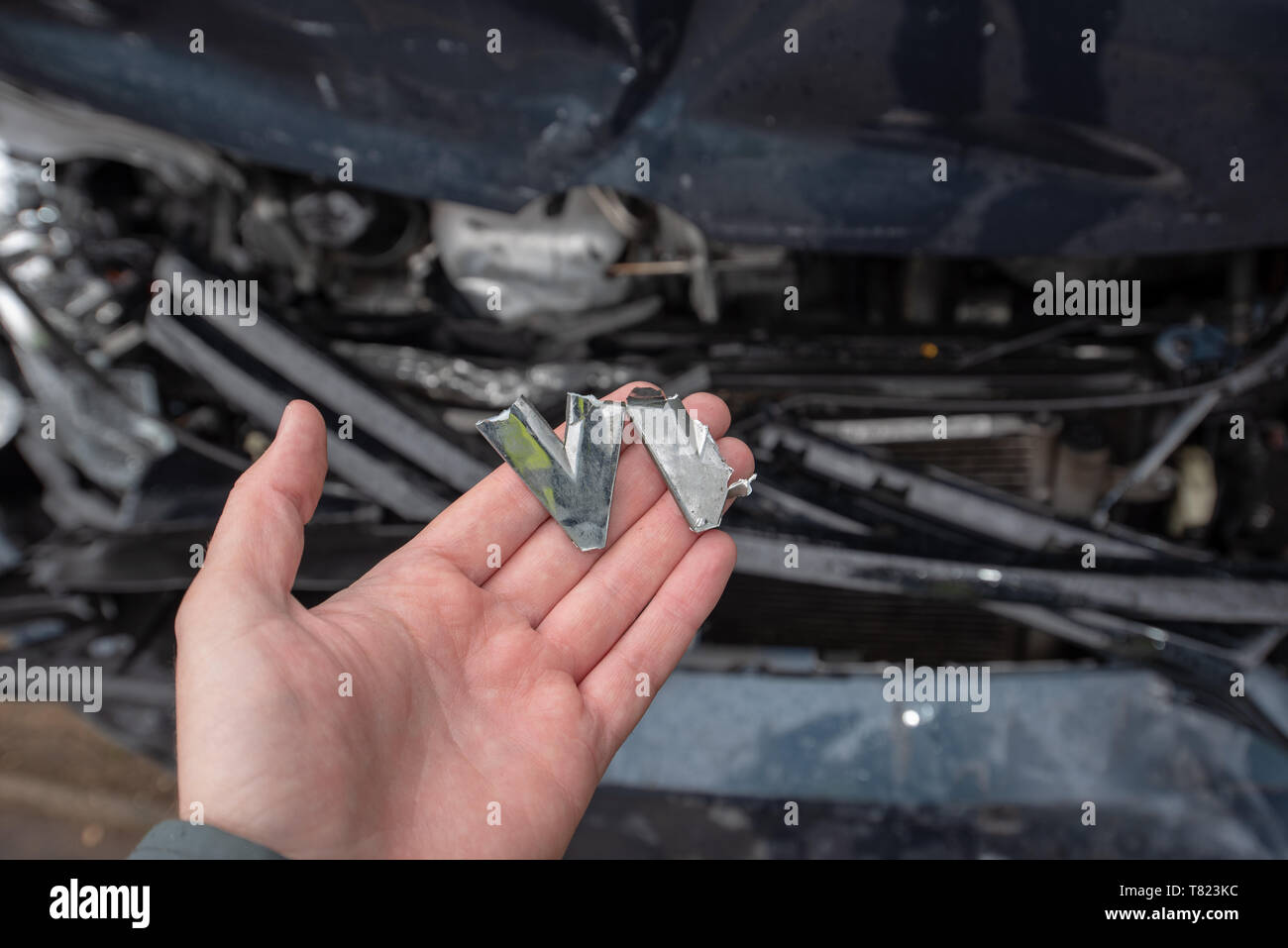 Volkswagen Badge, smashed badge and engine components. Car crash ...