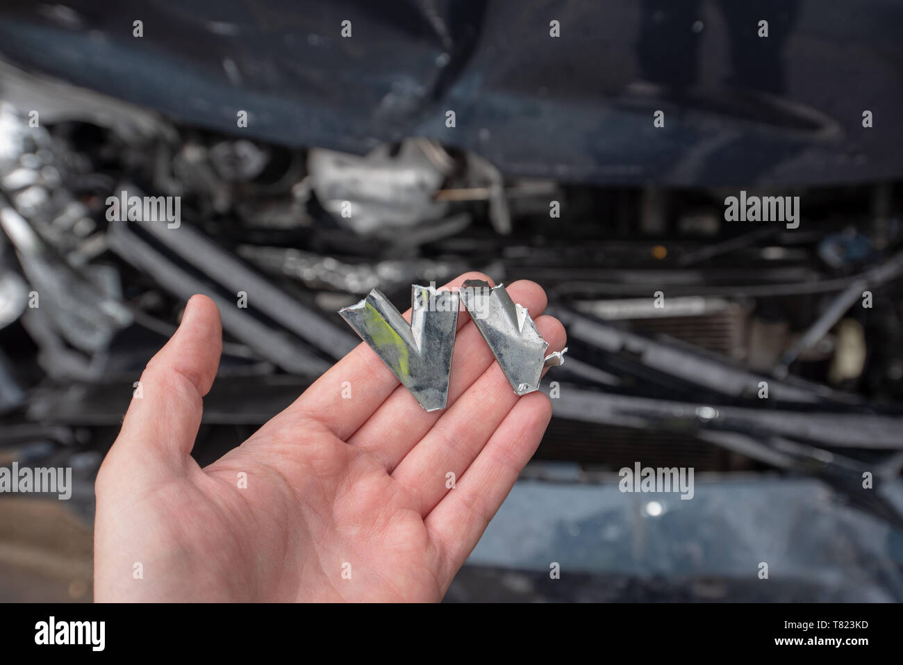 Volkswagen Badge, smashed badge and engine components. Car crash ...