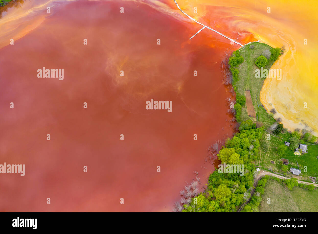 Aerial view of colorful red copper mining waste water in contrast with ...