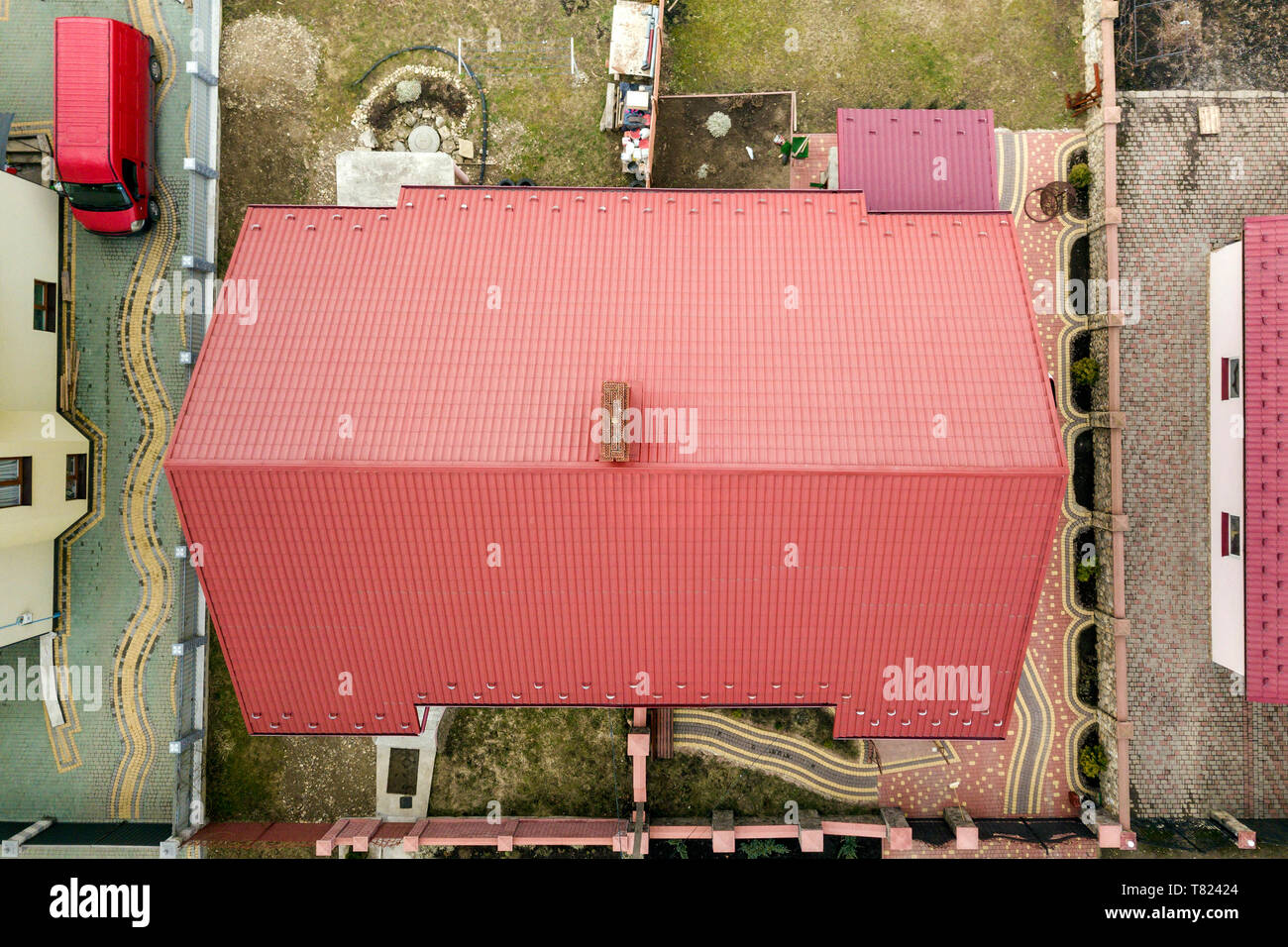 Aerial top view of house metal shingle roof on fenced yard background ...