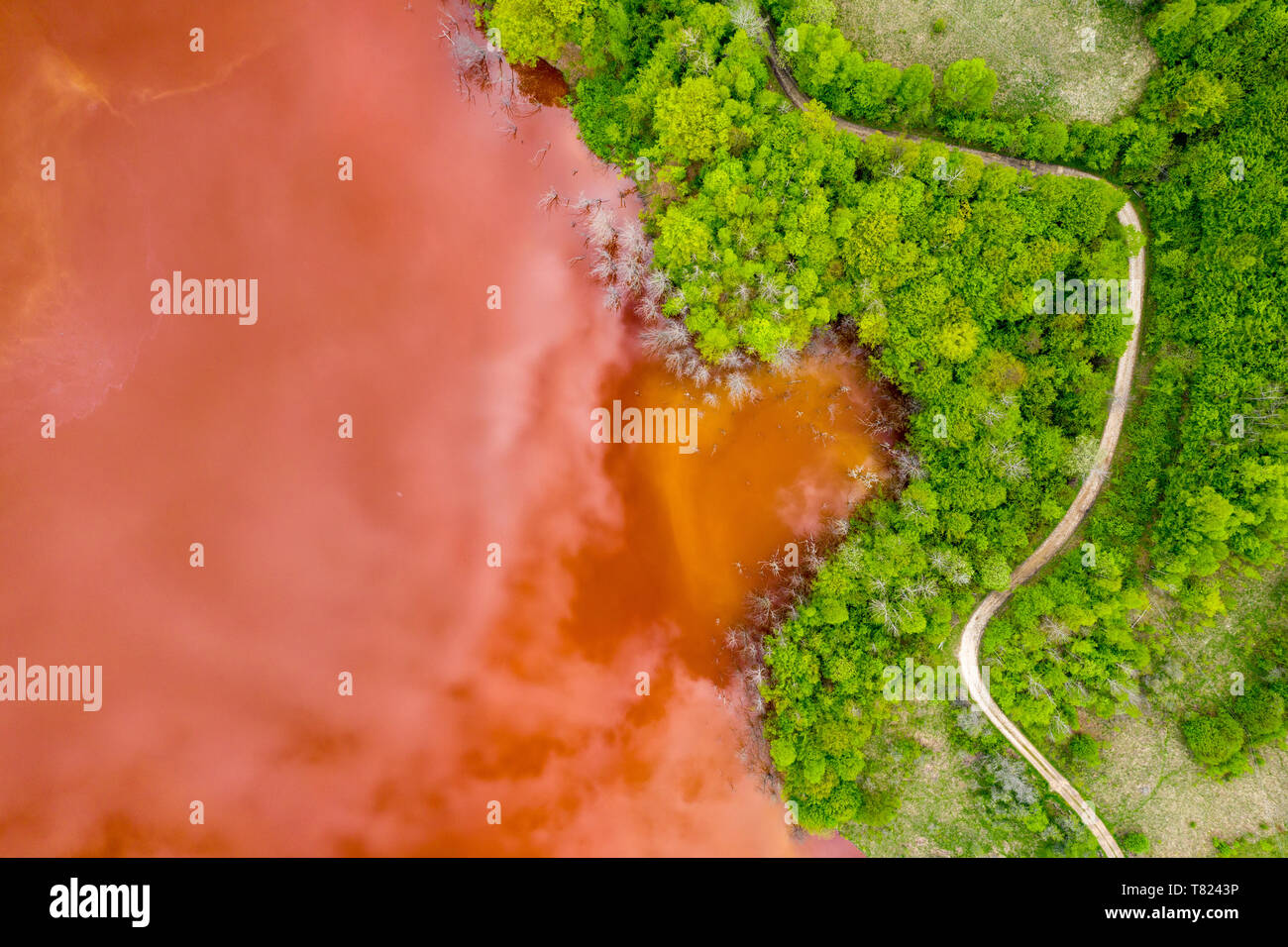 Aerial view of colorful red copper mining waste water in contrast with ...