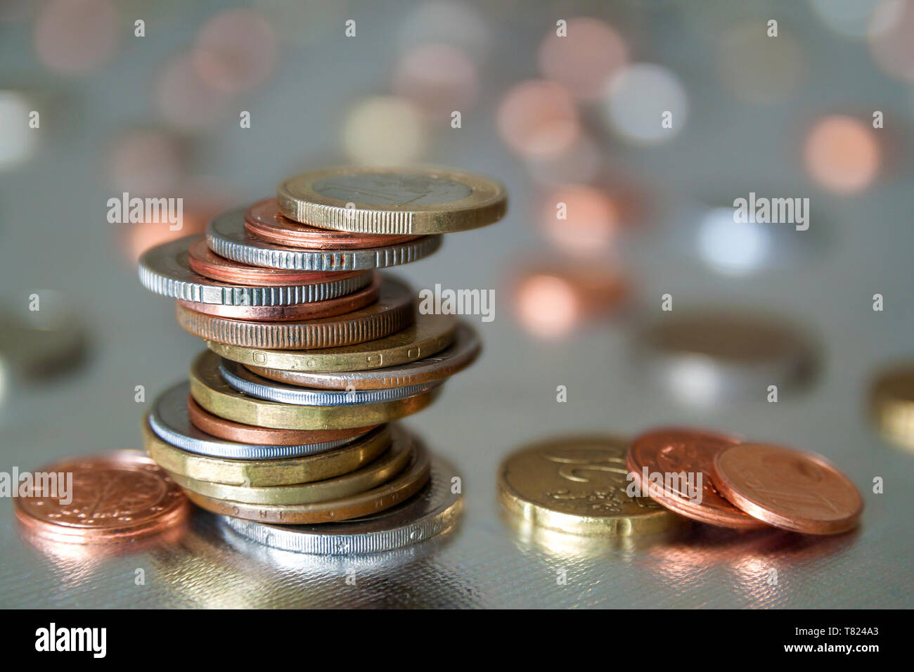 Pile of shiny coins different sizes and colors stacked unevenly on each ...