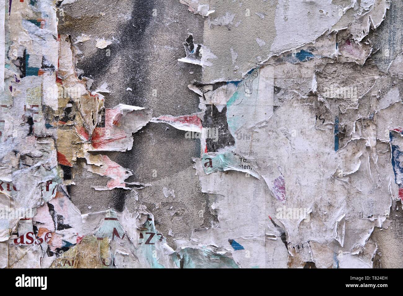 Old paper posters and advertisements torn off an urban wall. Background ...