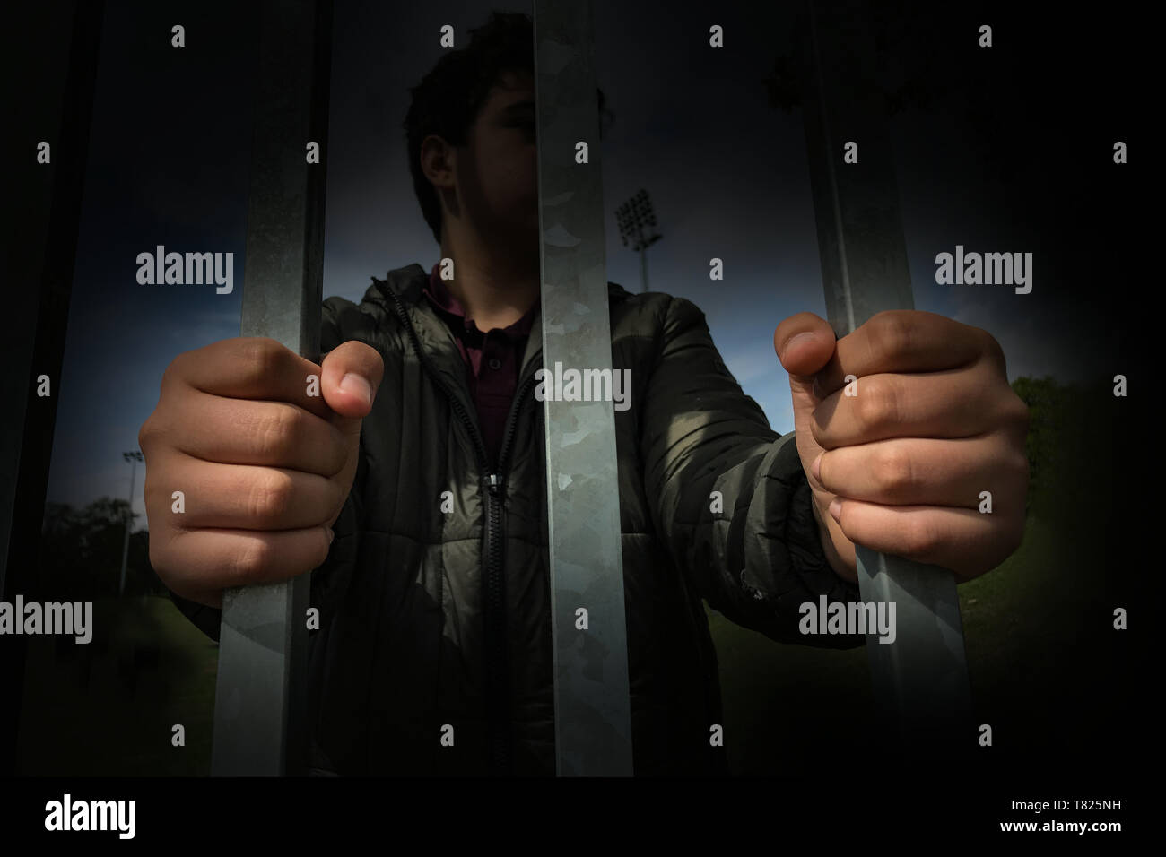 Teenager boy hands holding strong iron bars. Immigrant and refugee ...