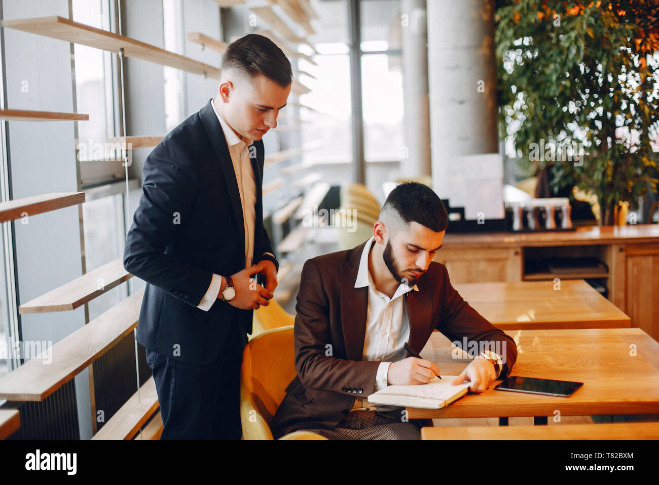 Two handsome men working. Friends in a cafe. Man in a suit Stock Photo ...