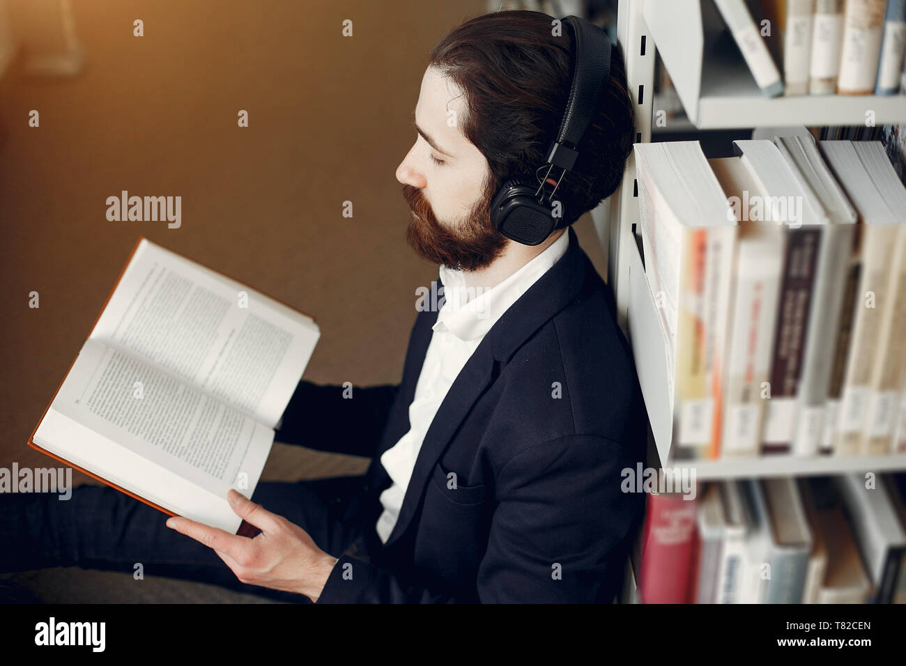 Man in a library. Guy in a black suit. Student with a books Stock Photo ...