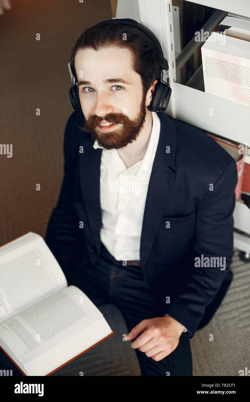 Man in a library. Guy in a black suit. Student with a books Stock Photo ...