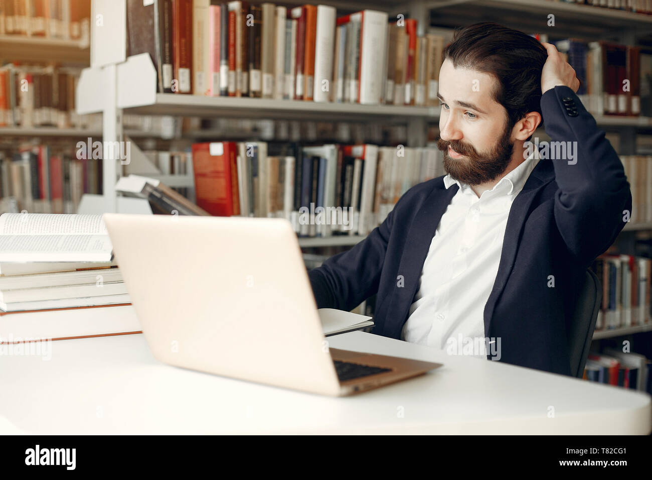 Man in a library. Guy in a black suit. Student with a books Stock Photo ...