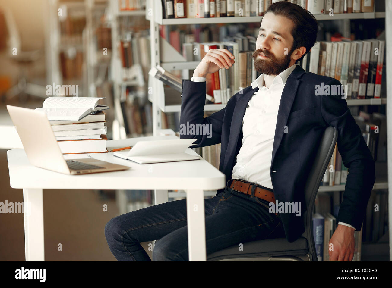 Man in a library. Guy in a black suit. Student with a books Stock Photo ...