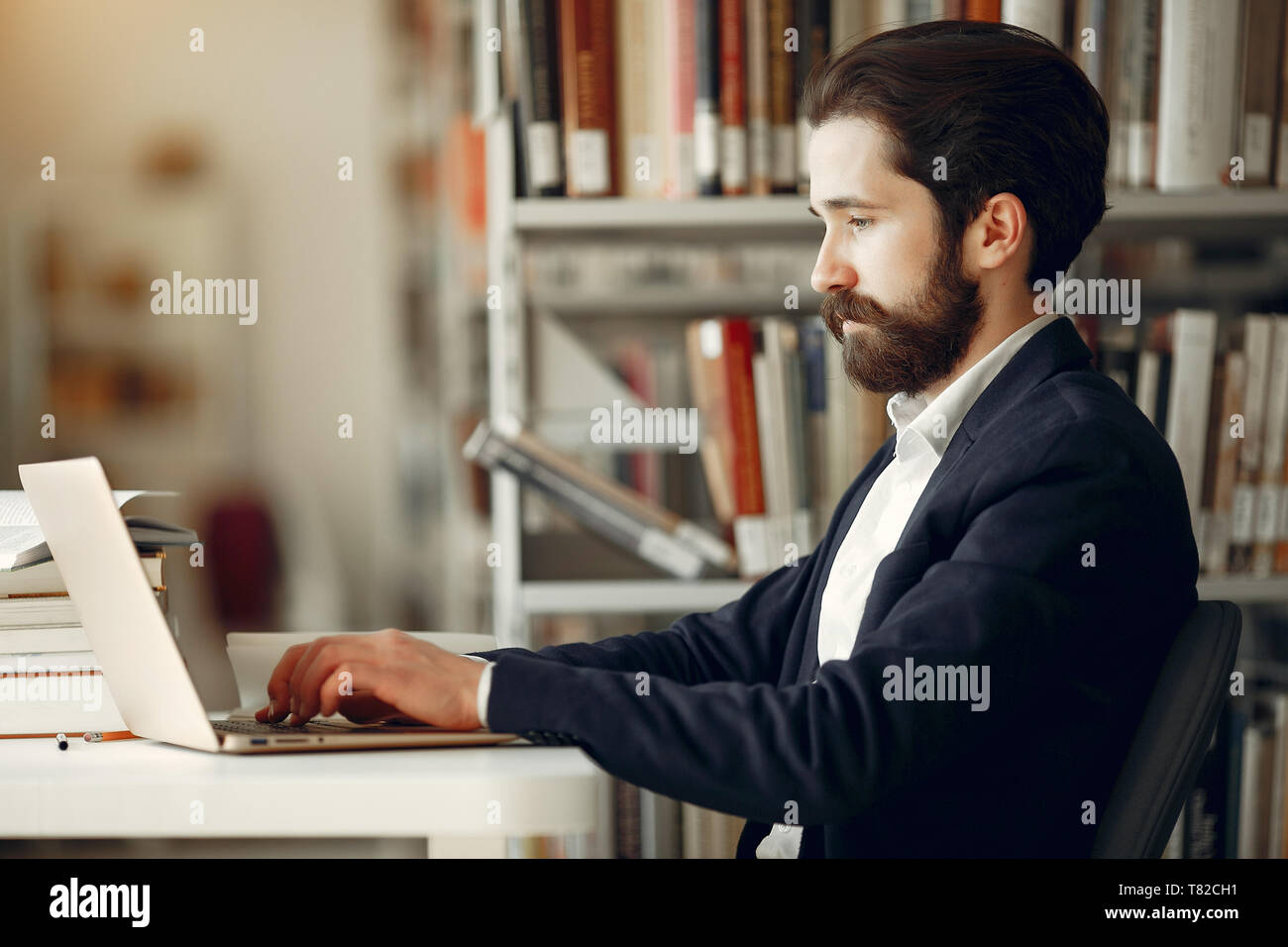 Man in a library. Guy in a black suit. Student with a books Stock Photo ...