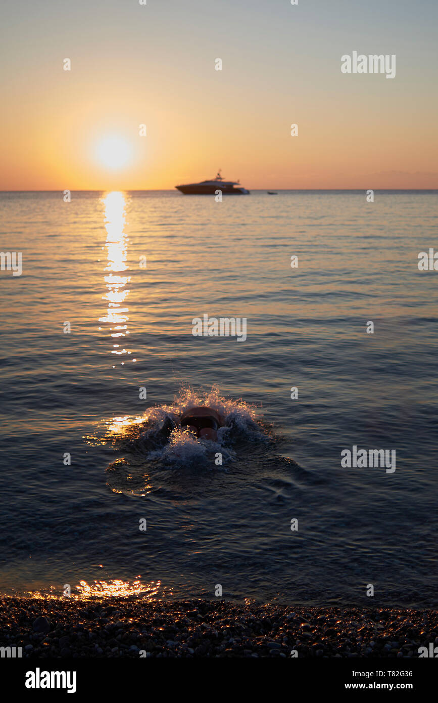 Man going for his healthy routine early morning swim in the calm waters ...