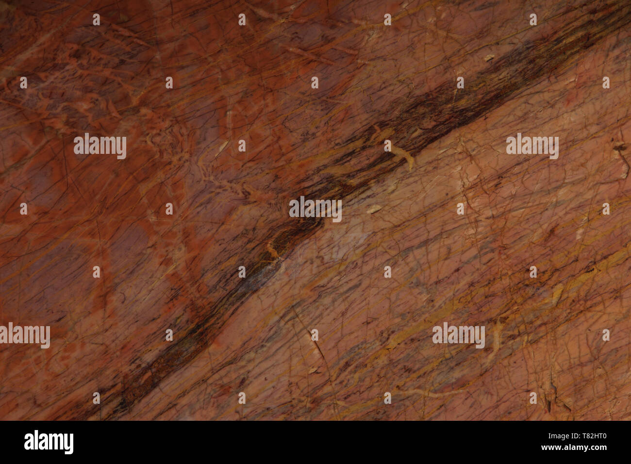 Natural stone of red color with yellow and claret veins Stock Photo - Alamy