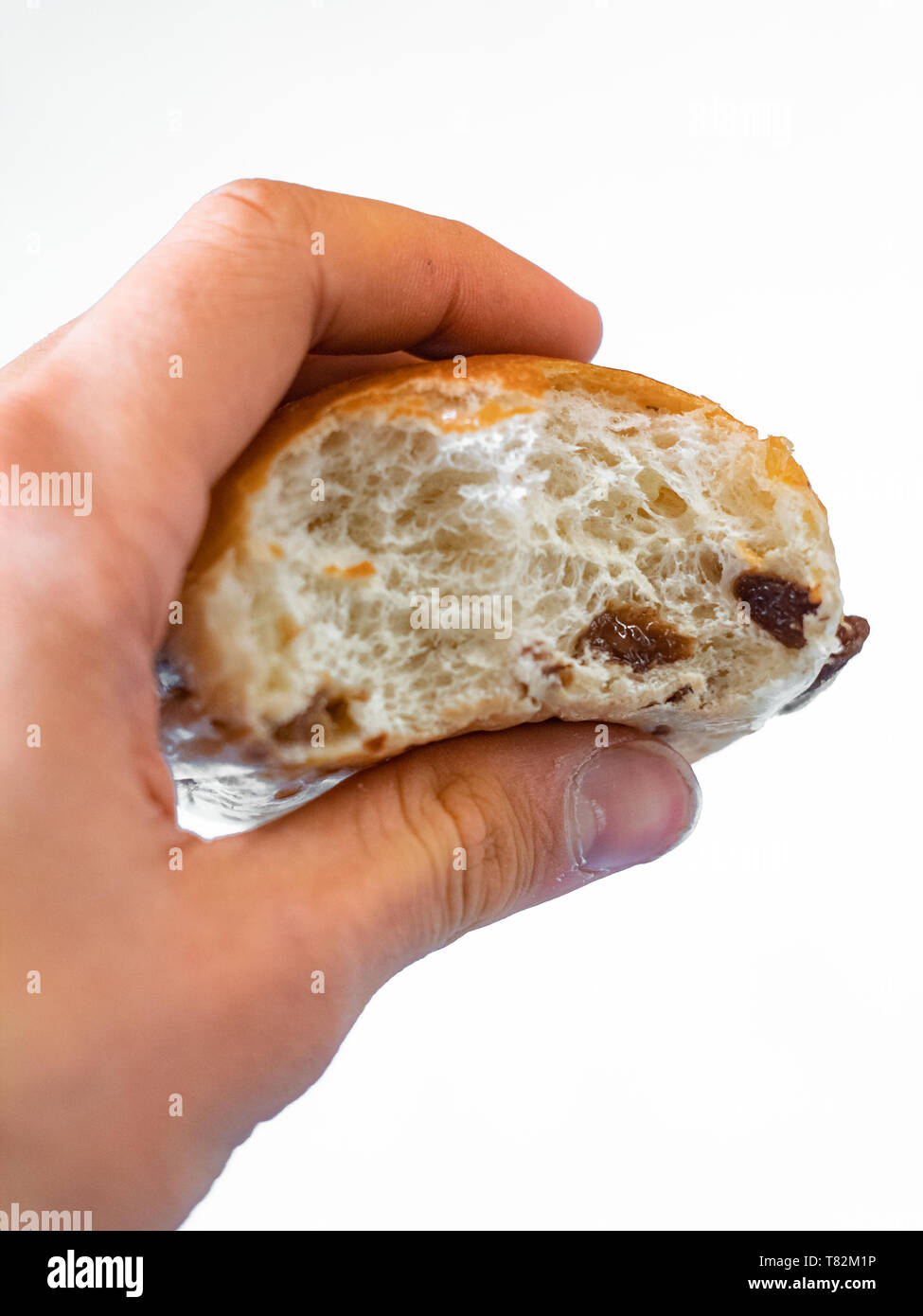 Bite off of bun with raisins. White background Stock Photo - Alamy