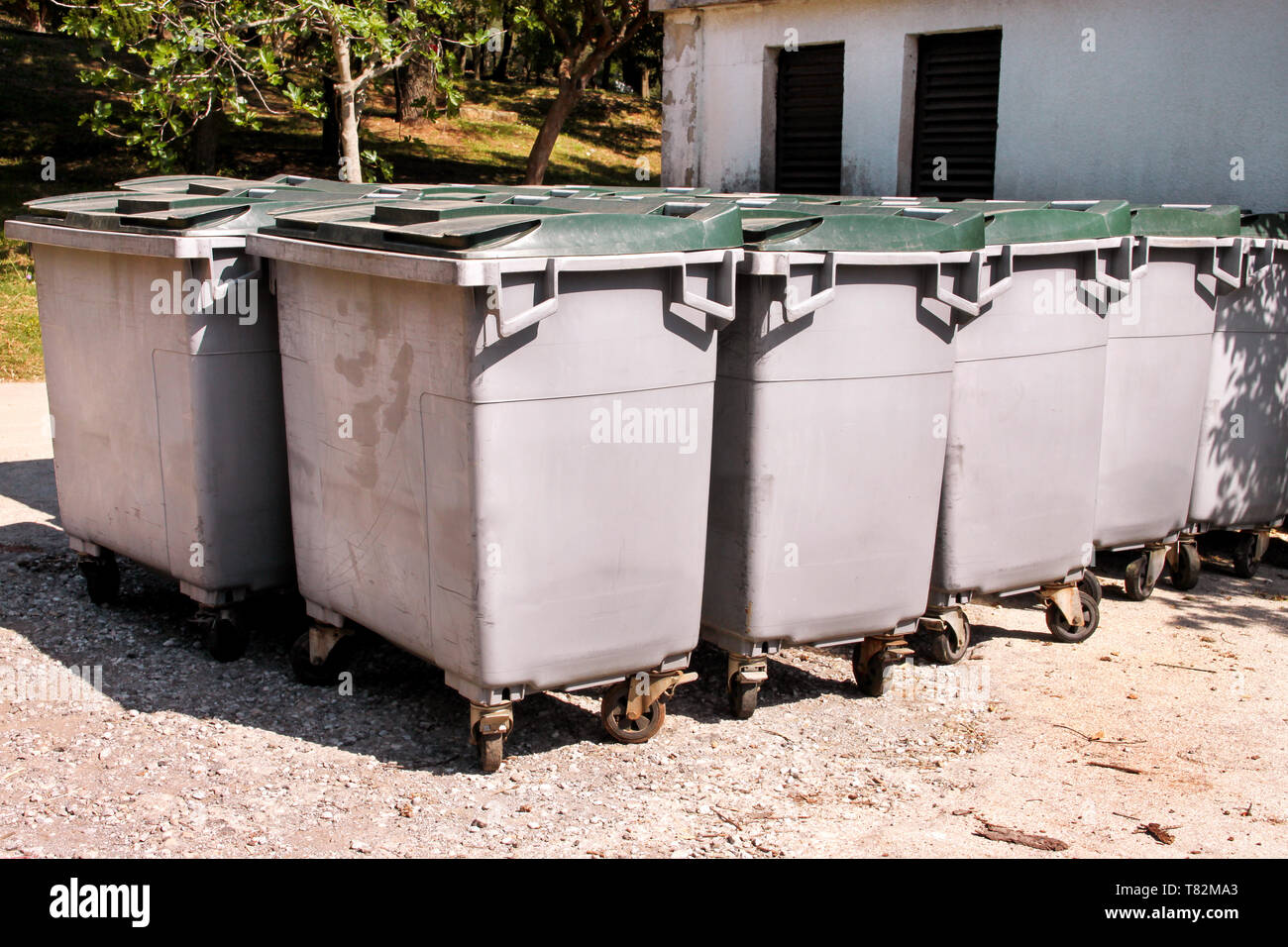Large garbage containers, trash dumpsters and bins standing in row ...