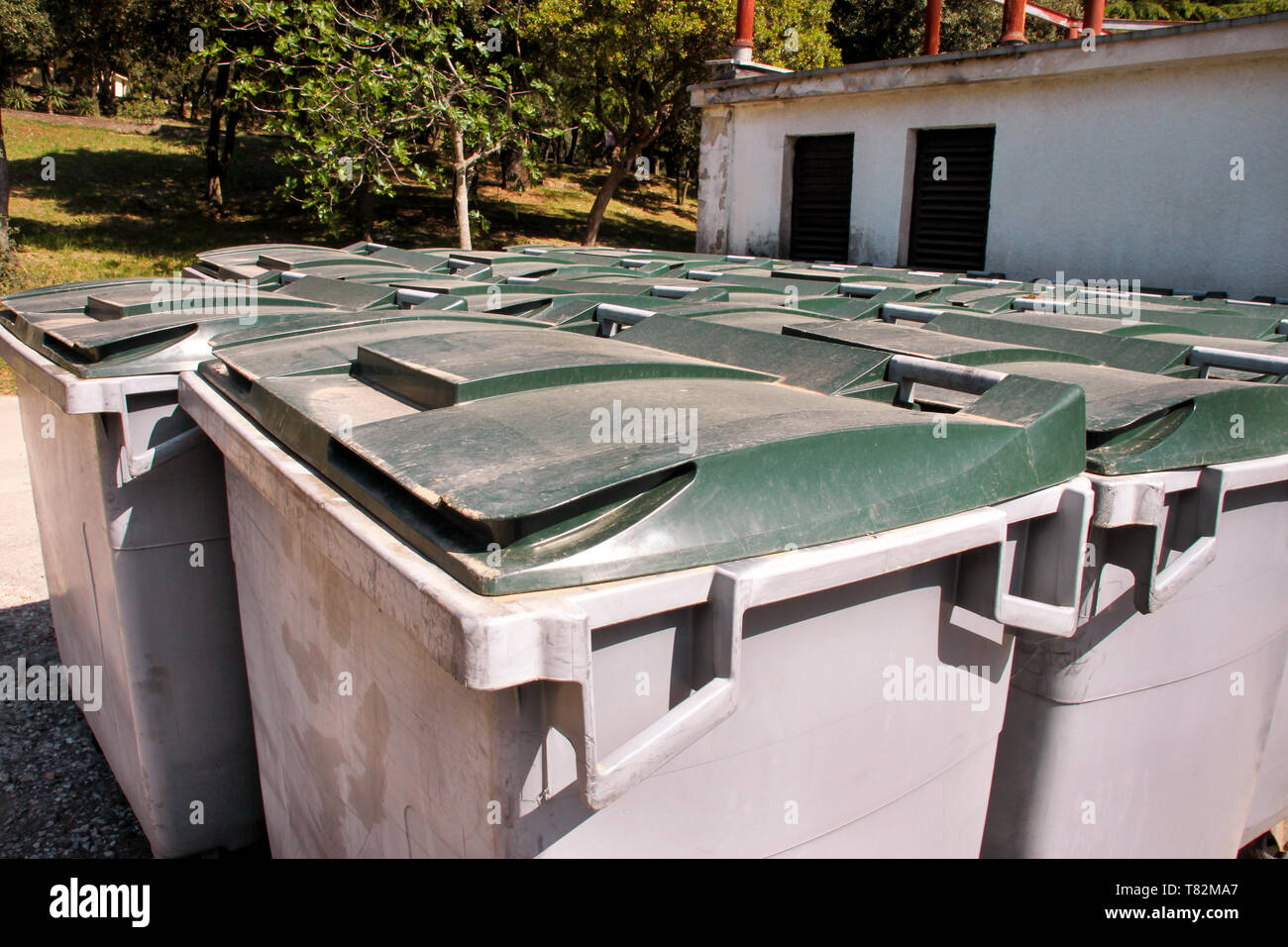 Large garbage containers, trash dumpsters and bins standing in row ...