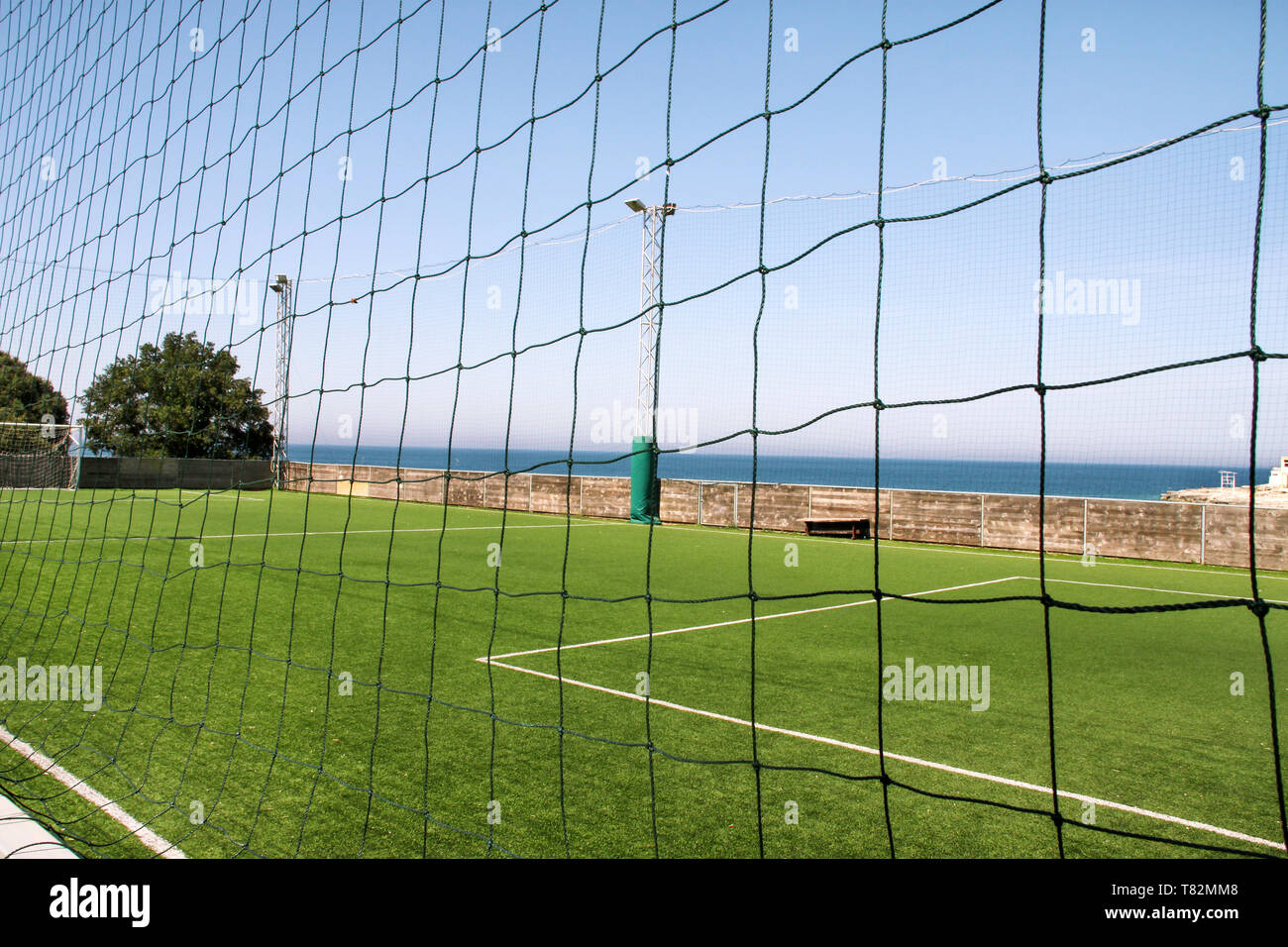 Look through net to empty football field in soccer stadium. Soccer ...