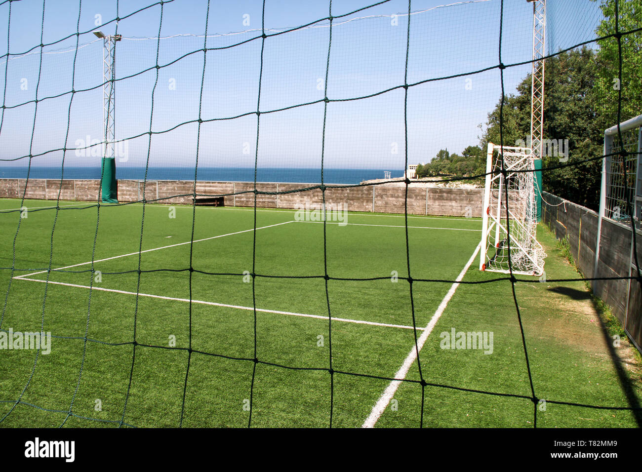 Look through net to empty football field in soccer stadium. Soccer ...