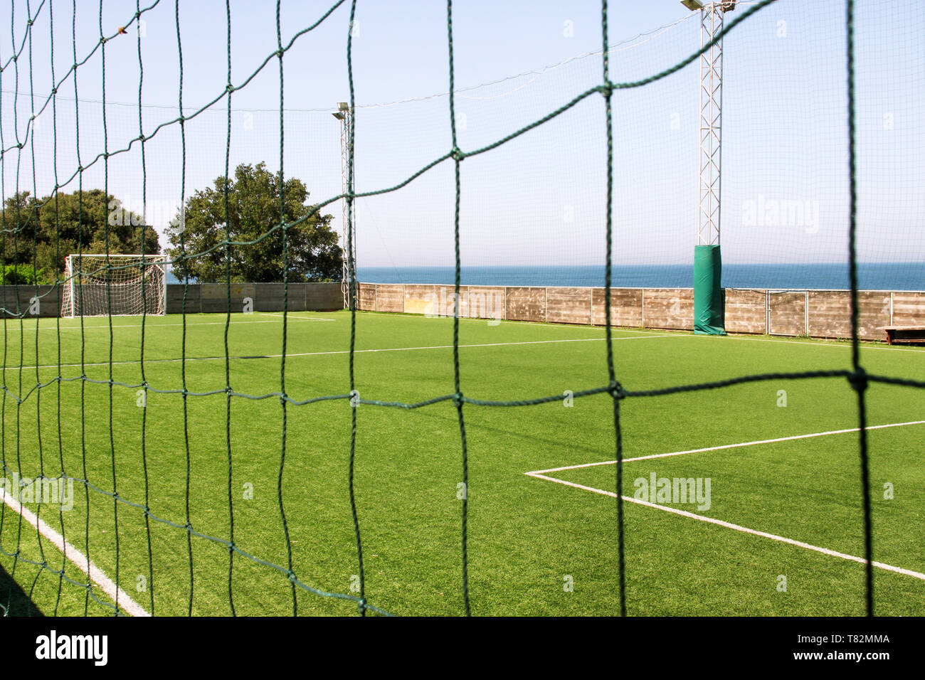 Look through net to empty football field in soccer stadium. Soccer ...