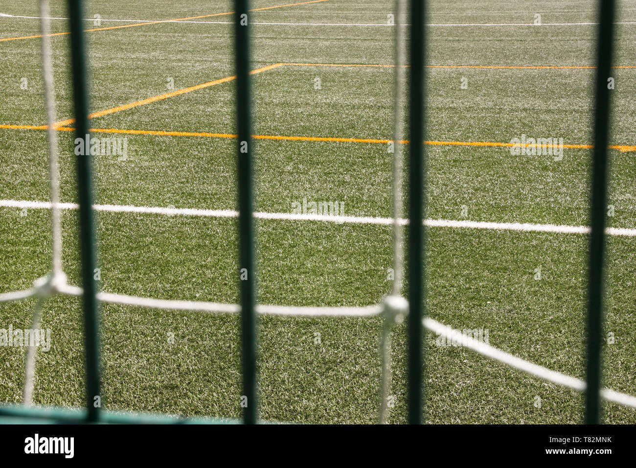 Look through net to empty football field in soccer stadium. Soccer ...